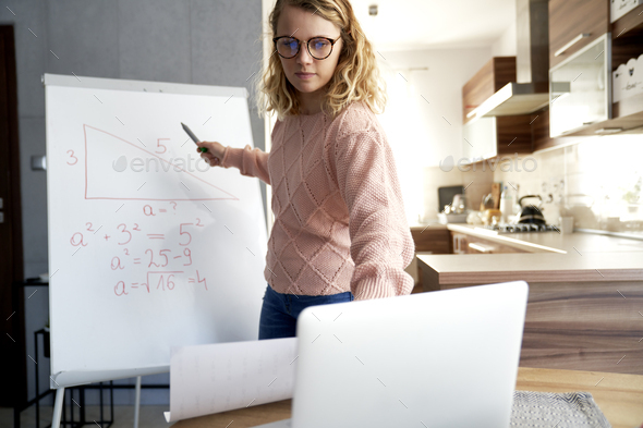 Teacher explains math tasks while homeschooling Stock Photo by gpointstudio