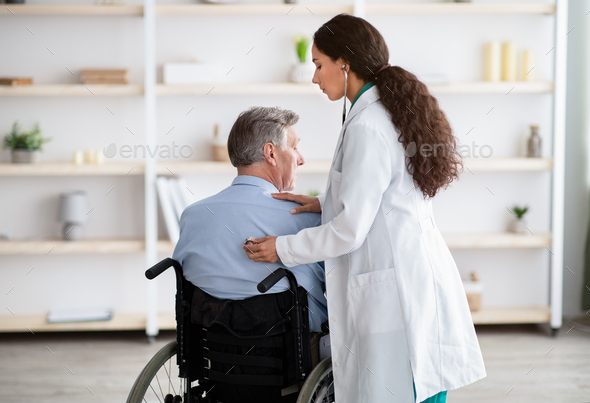 Elderly patient with physical disability receiving medical help from ...