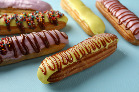 Tasty eclairs with different topping on blue background Stock Photo by ...