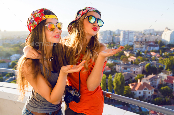 Outdoor lifestyle portrait of two best fiends sisters girls posing on ...