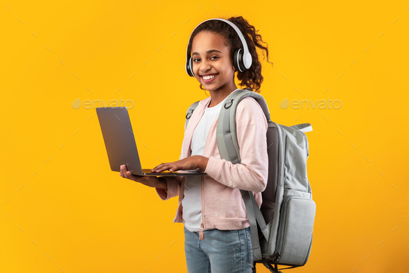 Black girl standing with laptop at studio Stock Photo by Prostock-studio