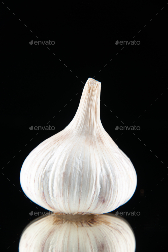Close up view of fresh garlic pod on black background with free space ...