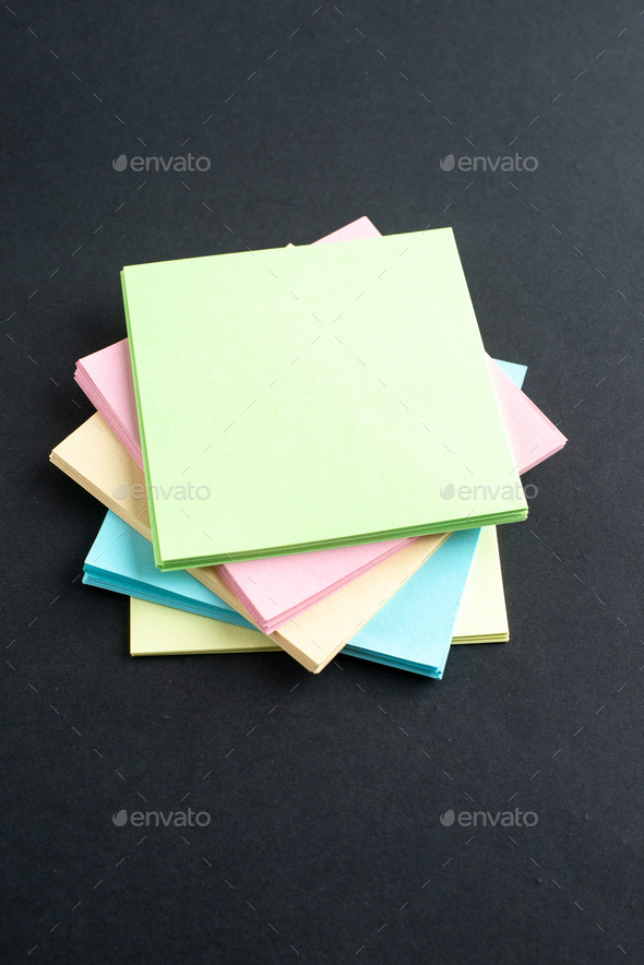 Side view of stacked sticky coloured note cubes on isolated black wave ...