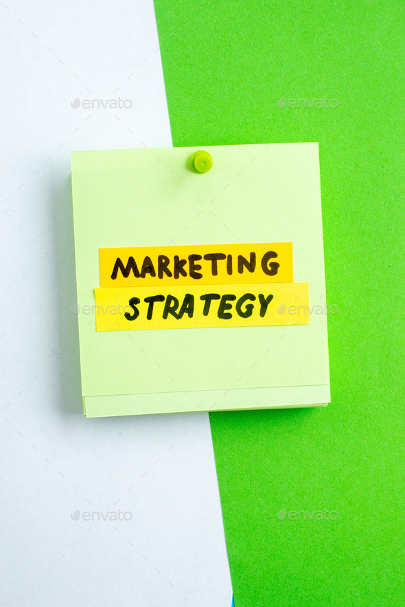 Vertical view of MARKETING STRATEGY writing on sheet on white green mix ...