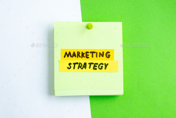 Top view of MARKETING STRATEGY writing on sheet on white green mix ...