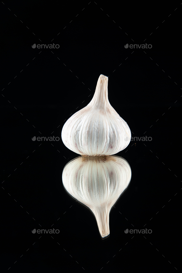 Vertical view of fresh garlic pod on black background with free space ...