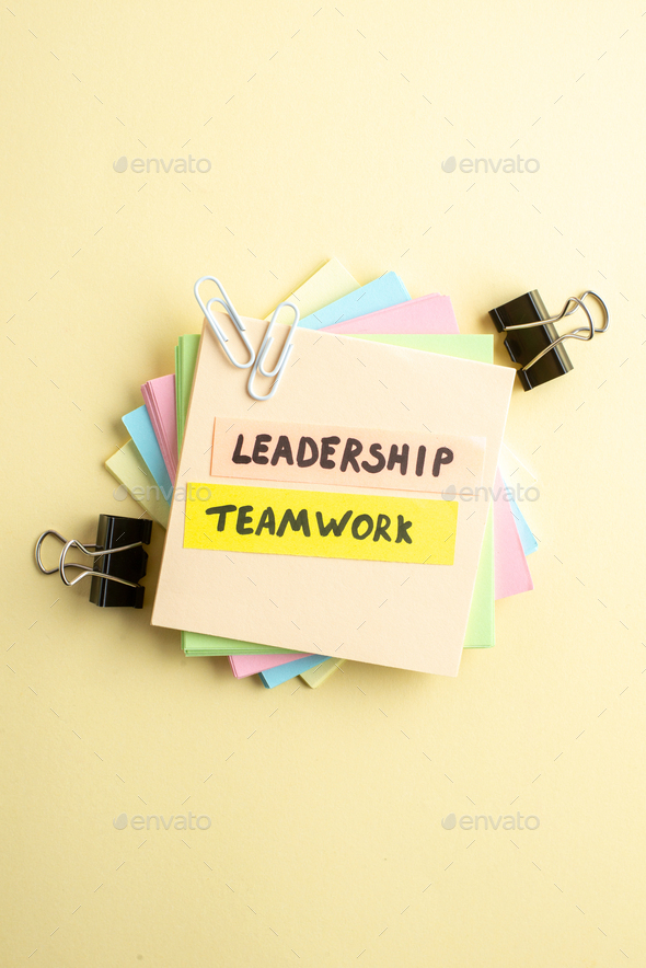 Vertical view of LEADERSHIP TEAMWORK writing on one of stacked sticky ...