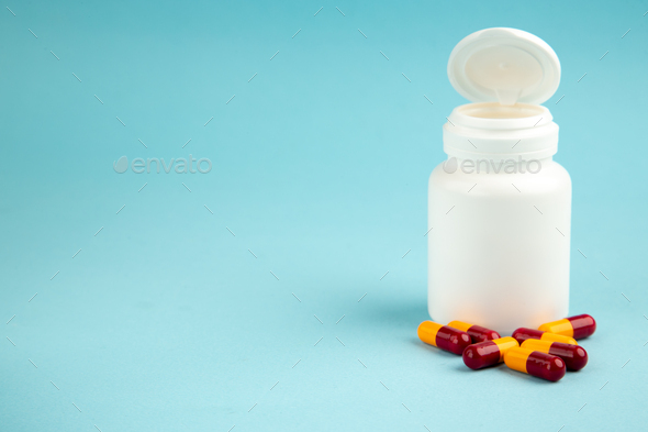 front view little pills can with pills on blue background color virus ...