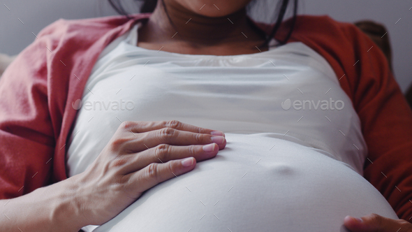 Young Asian Pregnant woman holding her belly talking with her child ...