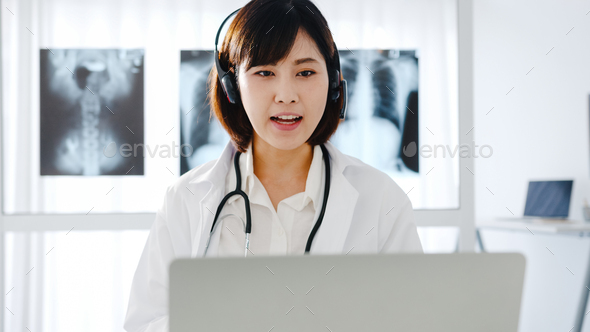 Asia female doctor using computer laptop talking video conference call ...