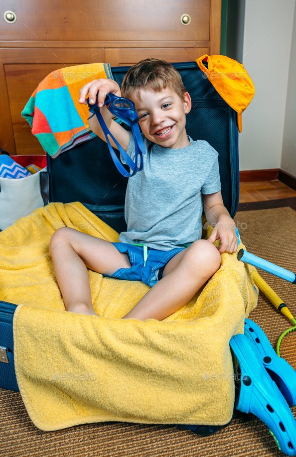 Happy boy smiling sitting inside a suitcase Stock Photo by davidpereiras