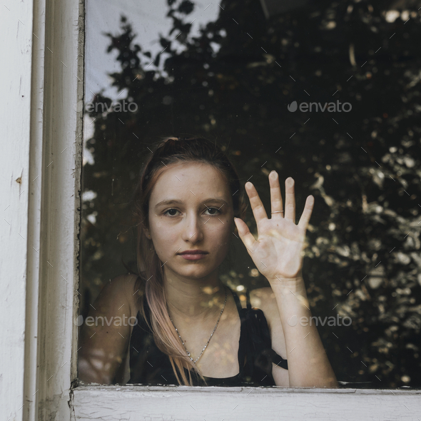 Sad girl staring out the window during a lockdown. Stock Photo by Rawpixel