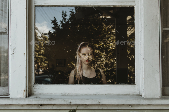 Sad girl staring out the window during a lockdown. Stock Photo by Rawpixel