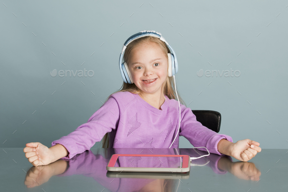 Cute little girl with Down Syndrome playing an online game on a digital ...