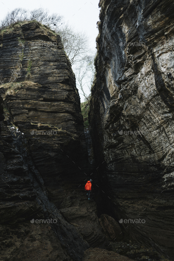 Hiker surrounded by dark cliffs Stock Photo by Rawpixel | PhotoDune