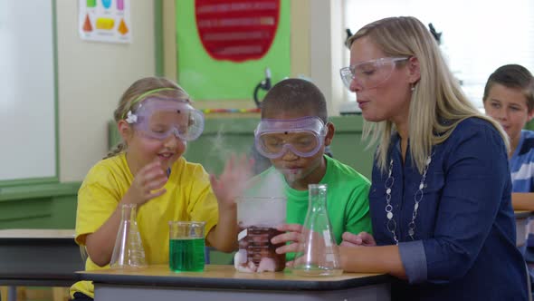 Teacher and students doing science experiment in school classroom ...