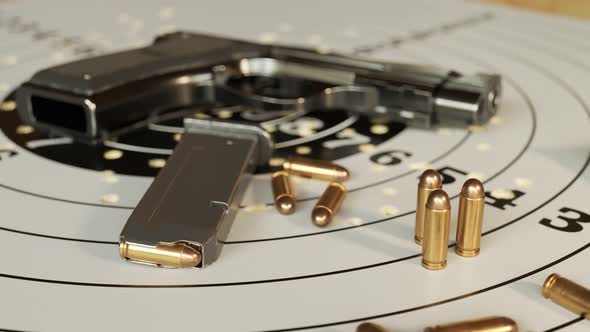 Gun and ammo on the shooting target. 9mm pistol with bullets and ...