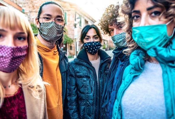 Community of multiracial people covered by facemasks looking at camera ...