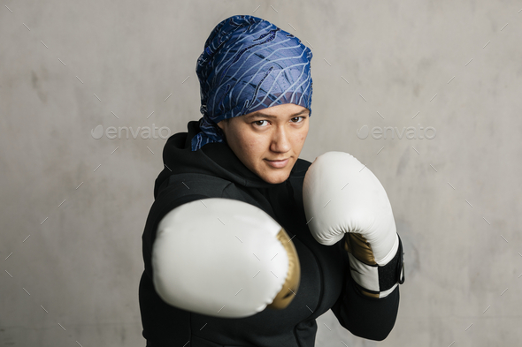 Young Islamic woman wearing a sport hijab while boxing Stock Photo by ...