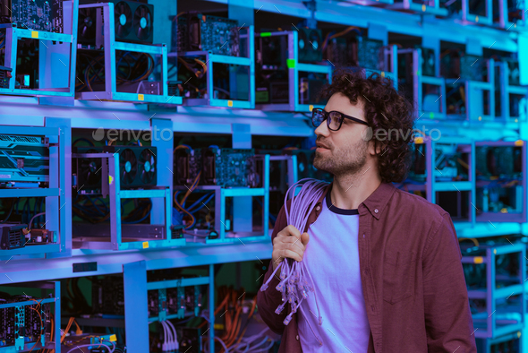 handsome computer engineer with wires on shoulder at ethereum mining ...