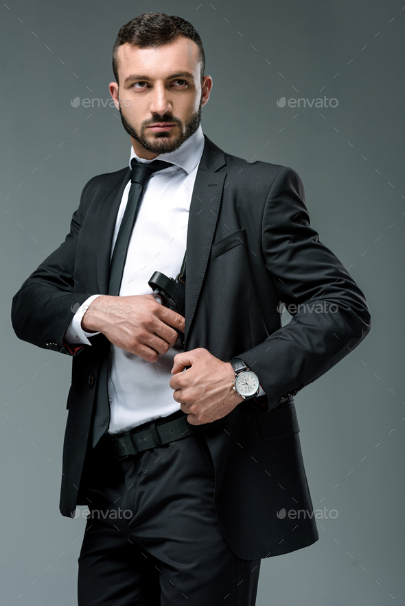 handsome security guard taking gun isolated on grey Stock Photo by ...