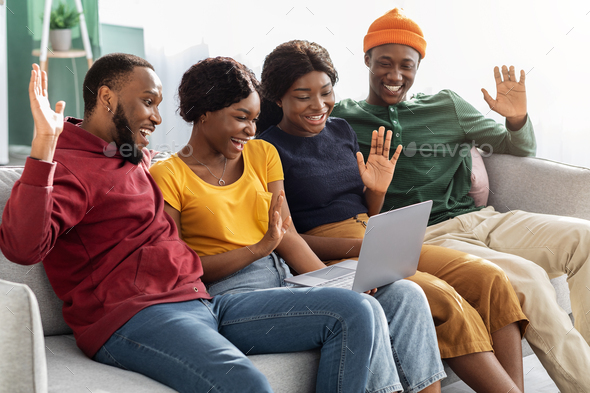 Group of black friends sitting on couch, having video call Stock Photo ...