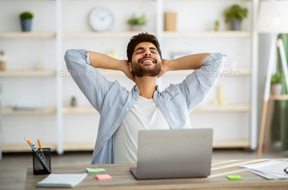 Break in work. Relaxed arab man leaning back in chair, resting after ...
