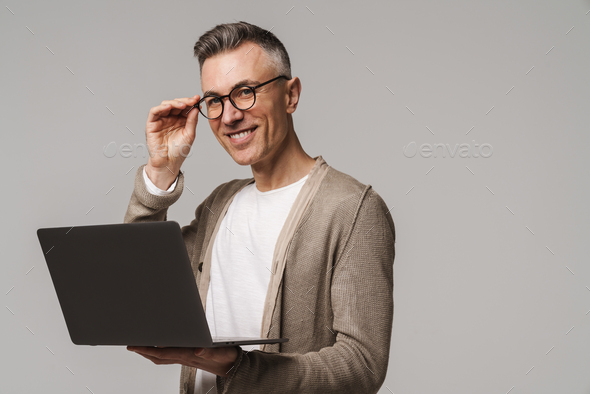 Confident handsome smart looking man standing Stock Photo by vadymvdrobot