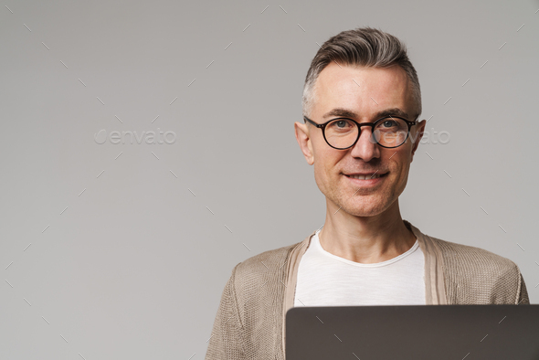 Confident handsome smart looking man standing Stock Photo by vadymvdrobot