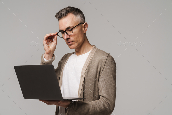 Confident handsome smart looking man standing Stock Photo by vadymvdrobot