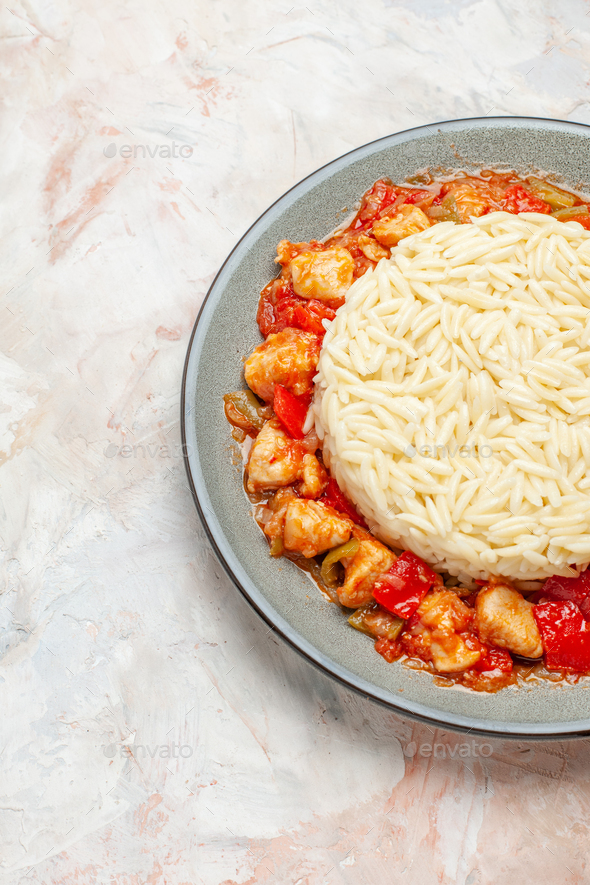 Vertical view of white rice meal with chicken and tomato on colorful ...