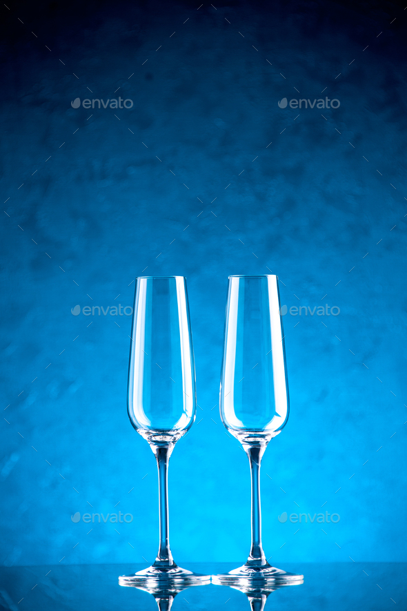 front view two champagne flutes on blue background Stock Photo by ...