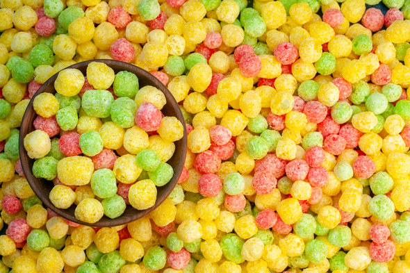 High resolution photo of a small brown pot on coloured sweets covering ...