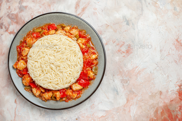Top view of white rice meal with chicken and vegetables on right side ...