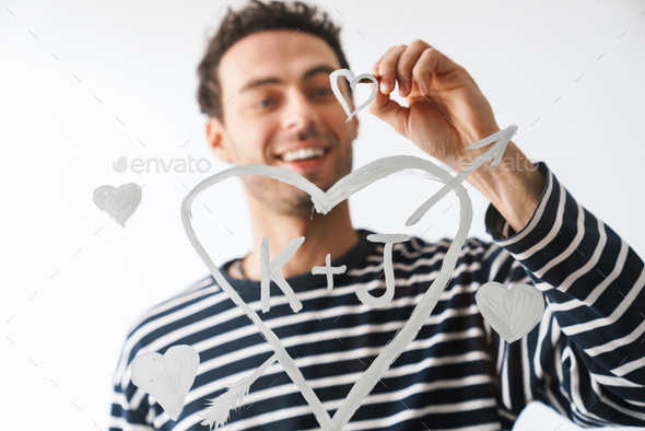 Smiling handsome young man in love drawing a heart symbol Stock Photo ...