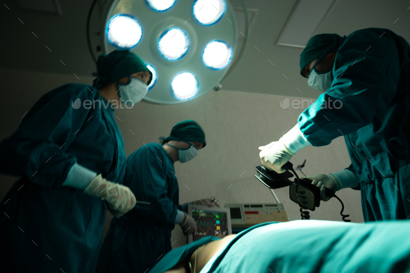 Medical team of surgeons in hospital doing invasive surgical ...