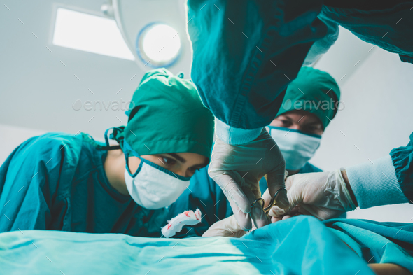 Medical team of surgeons in hospital doing invasive surgical ...