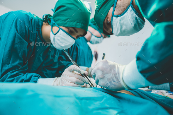 Medical team of surgeons in hospital doing invasive surgical ...