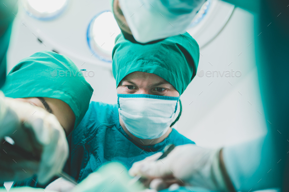 Medical team of surgeons in hospital doing invasive surgical ...