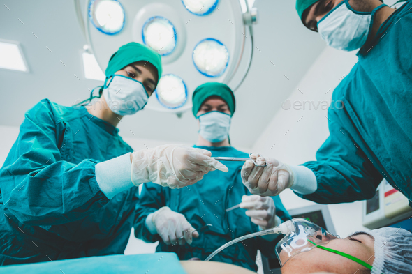 Medical team of surgeons in hospital doing invasive surgical ...