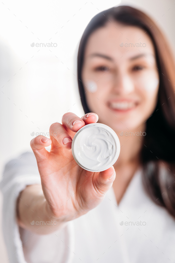 young smiling woman showing an open jar of face cream Stock Photo by ...