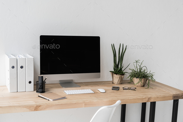 workplace with computer and flower pots in modern office Stock Photo by ...