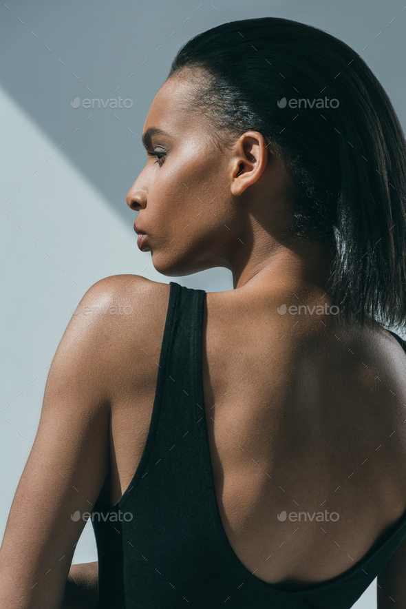back view of african american trendy seductive girl in black swimsuit ...