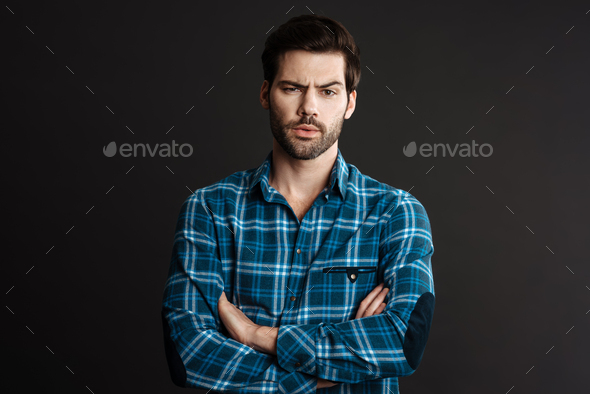 Perplexed handsome unshaven guy posing with arms crossed Stock Photo by ...