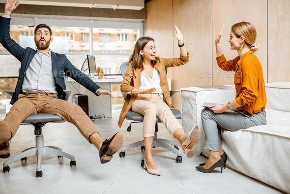 Playful employees having fun in the office Stock Photo by RossHelen