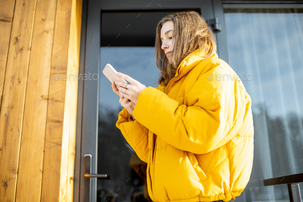 Woman locking smartlock with phone on the entrance door Stock Photo by ...
