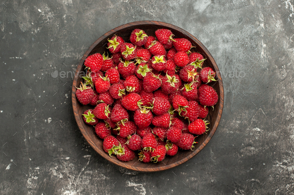 top view fresh red raspberries inside plate on a grey background color ...