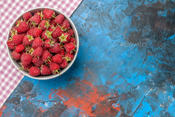 top view red raspberries inside plate on blue background photo taste ...