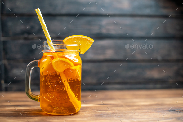 front view fresh orange juice inside can with straw on dark background ...