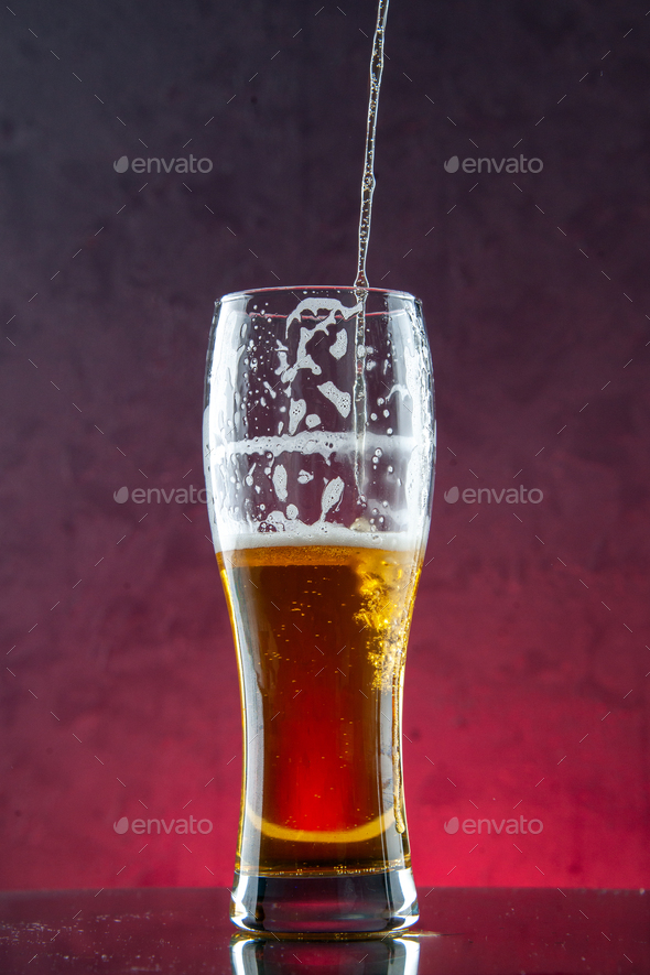 Top view of half-drunk home-brewed beer in a glass pouring from a ...